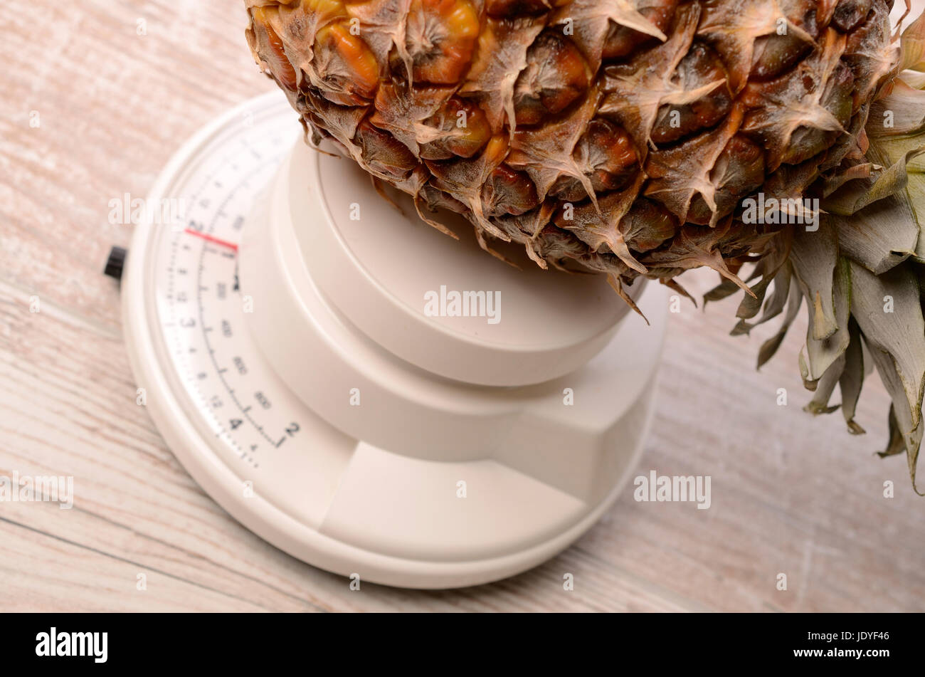 Pine apple on a scale Stock Photo - Alamy