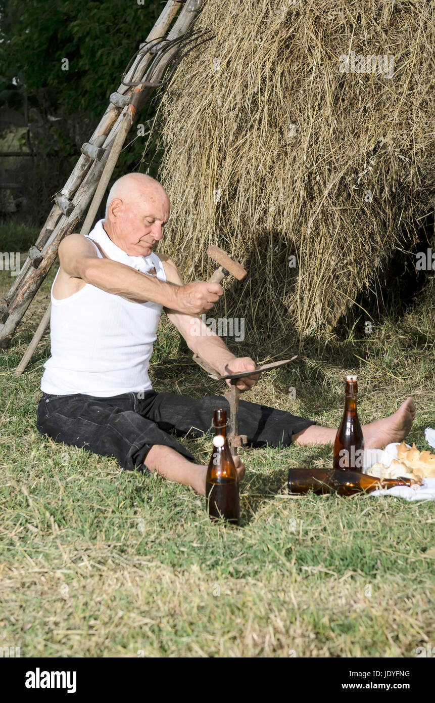 Farmer using scythe hi-res stock photography and images - Alamy