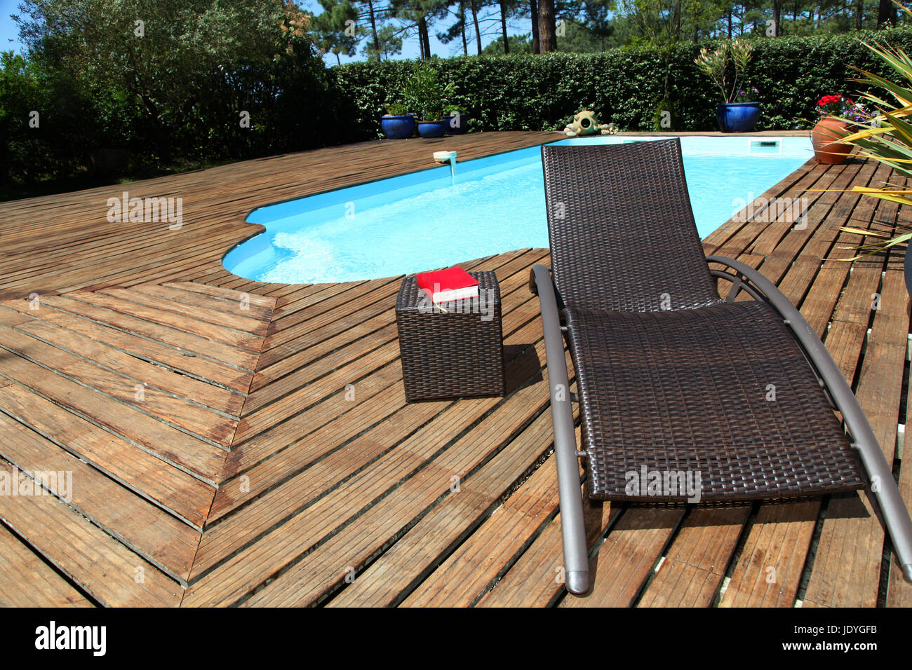 View of long chairs set by swimming pool Stock Photo - Alamy