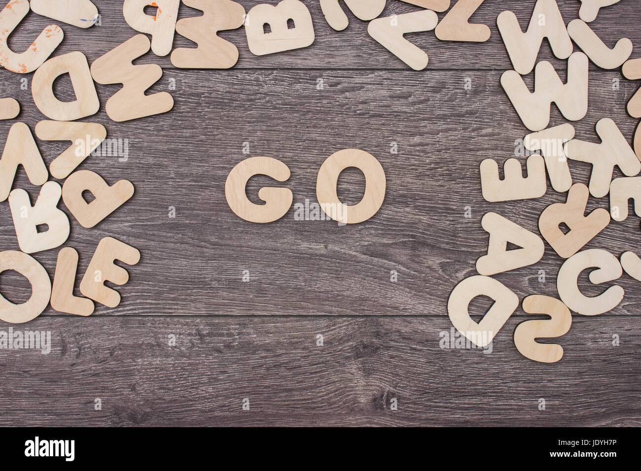 Word Go made with wooden letters next to a pile of other letters over ...