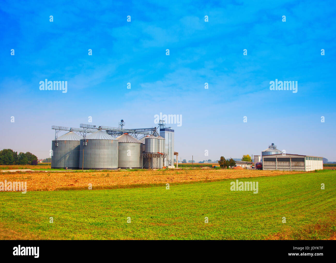 Industrial silos under blue sky, in the fields Stock Photo - Alamy