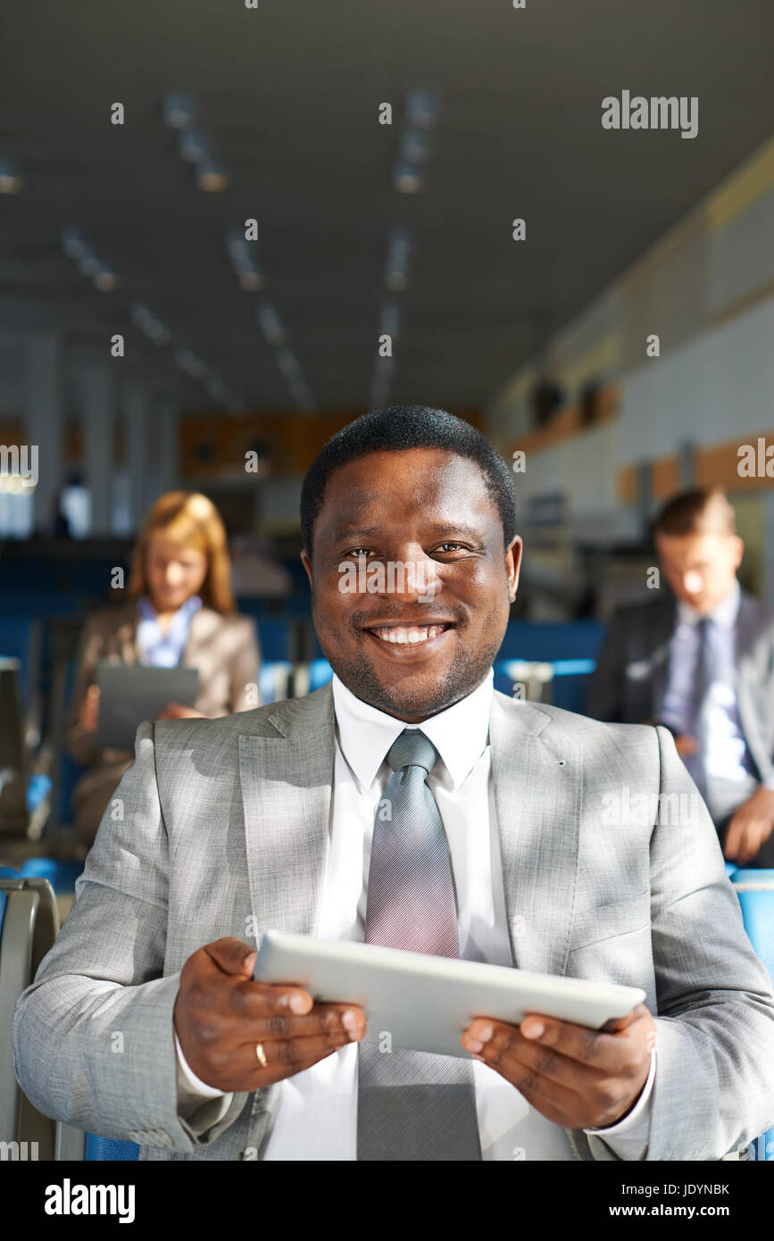Young African-american businessman with touchpad looking at camera with ...