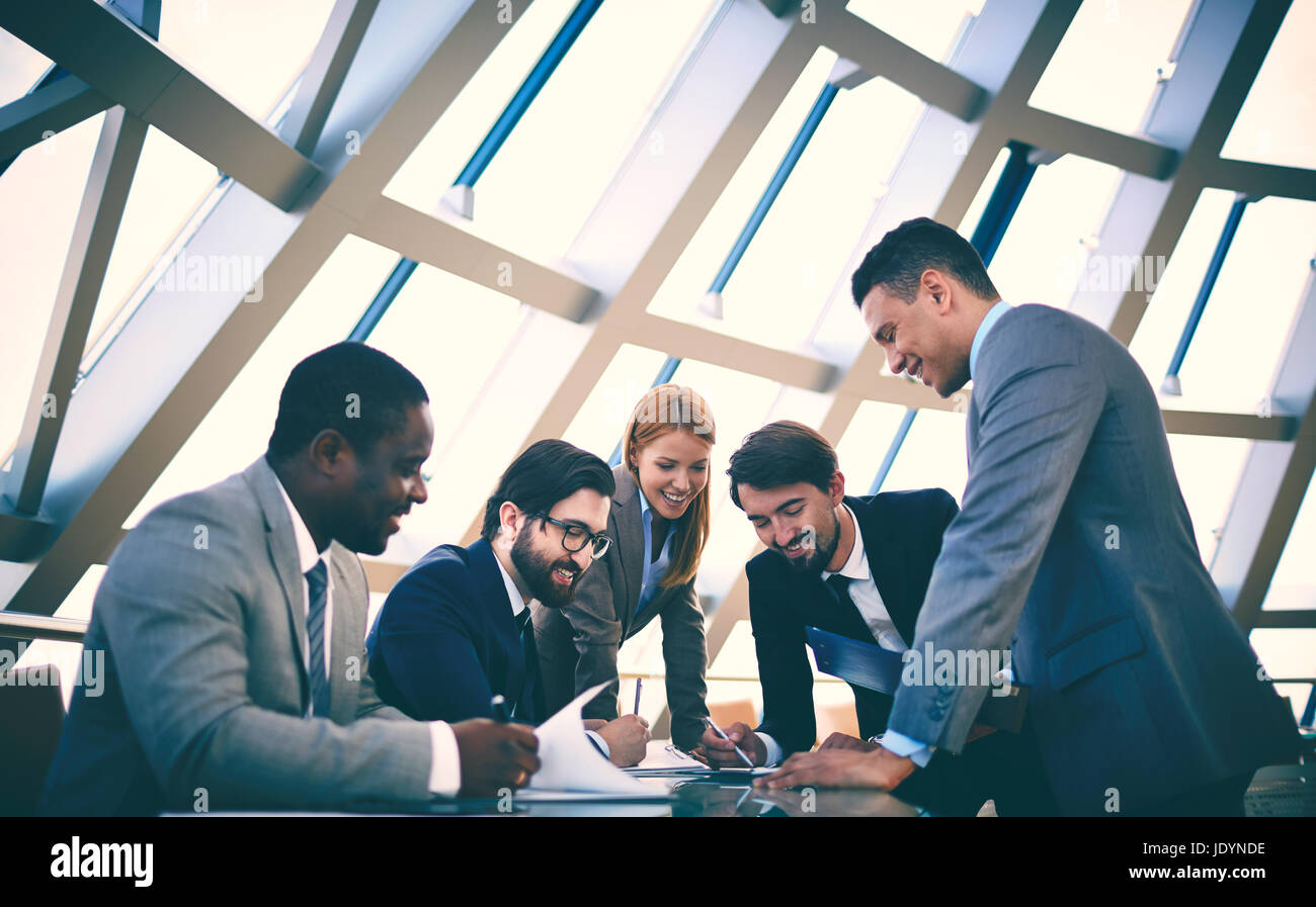 Group of happy business people discussing papers at meeting Stock Photo ...