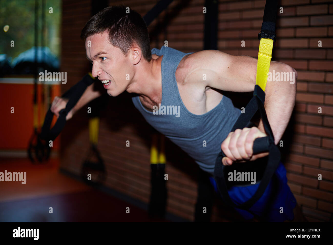 Young man doing difficult exercise for arm muscles Stock Photo - Alamy