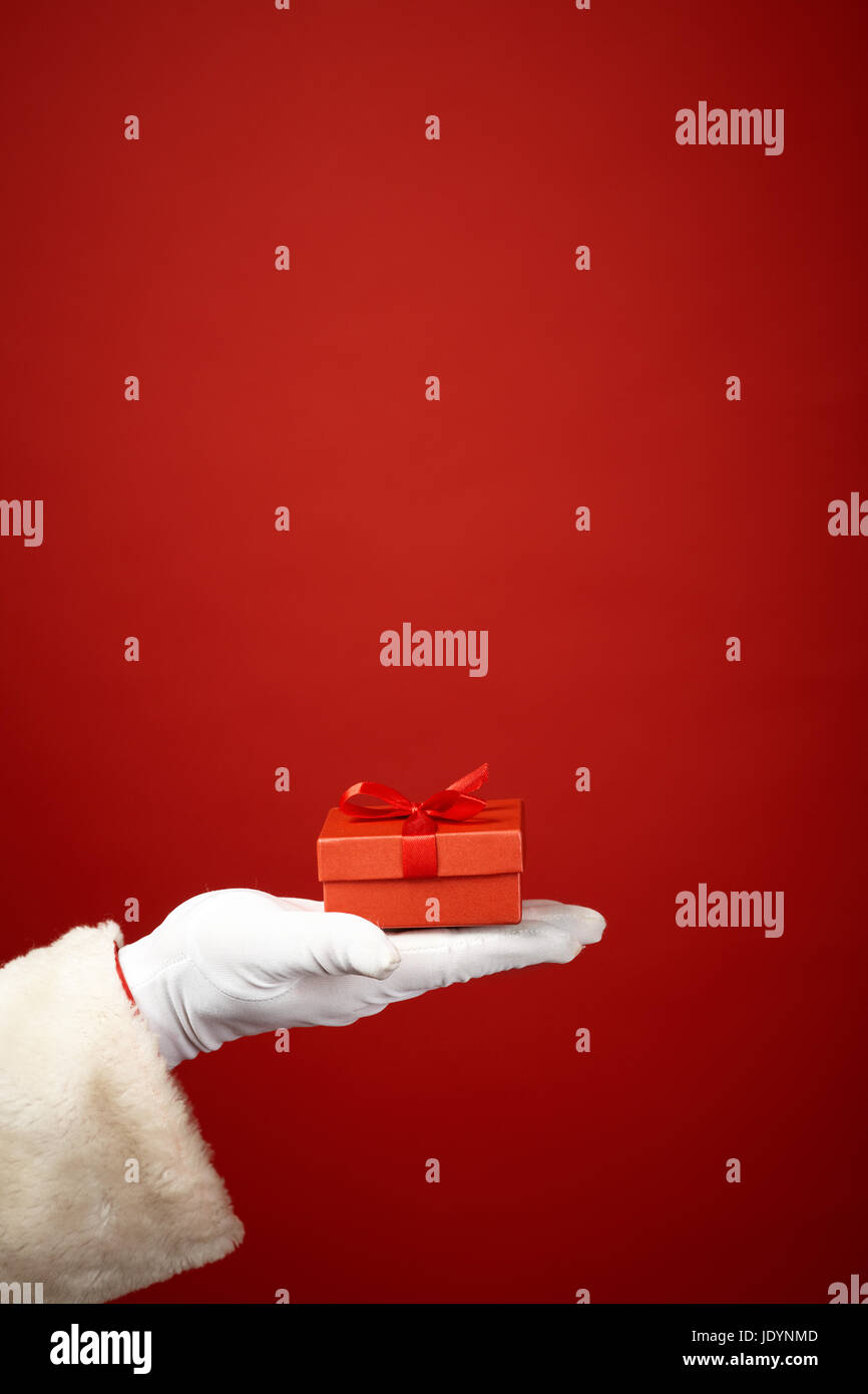 Santa Claus gloved hand with small package Stock Photo - Alamy
