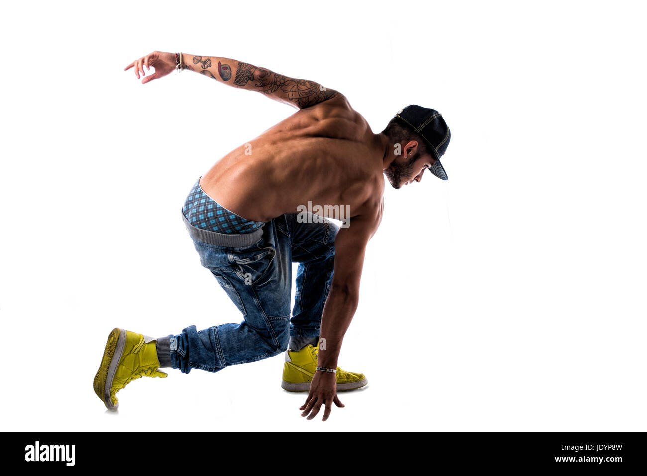 Athletic trendy shirtless young man in a hat doing a break dance ...
