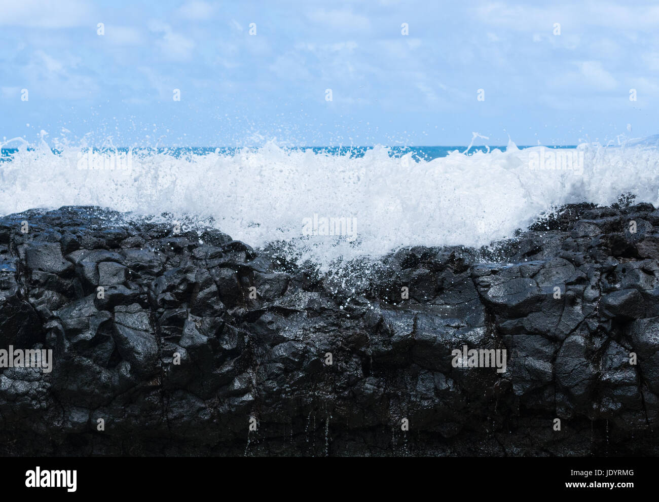 Frozen motion of ocean waterfall over rocks at Lumahai Beach Stock ...