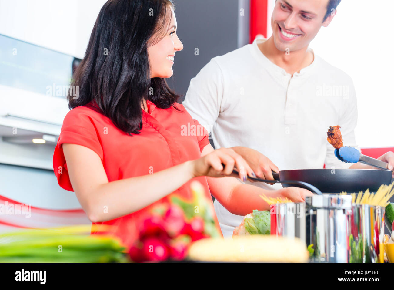 Woman and man cooking meat in domestic kitchen Stock Photo - Alamy