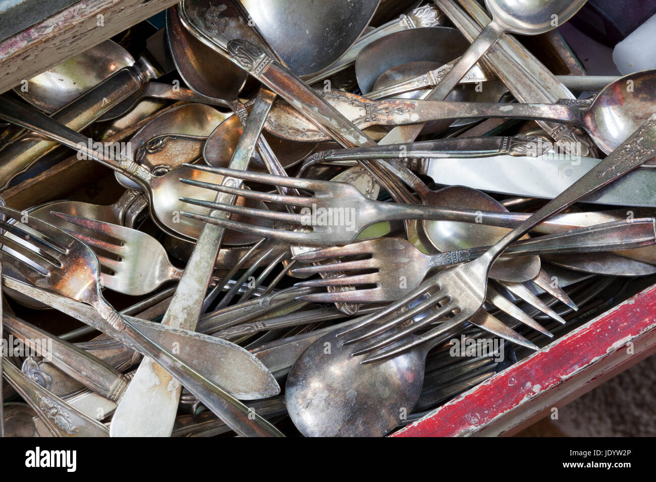 Cluttered kitchen drawer filled with a confusing jumble of silverware ...