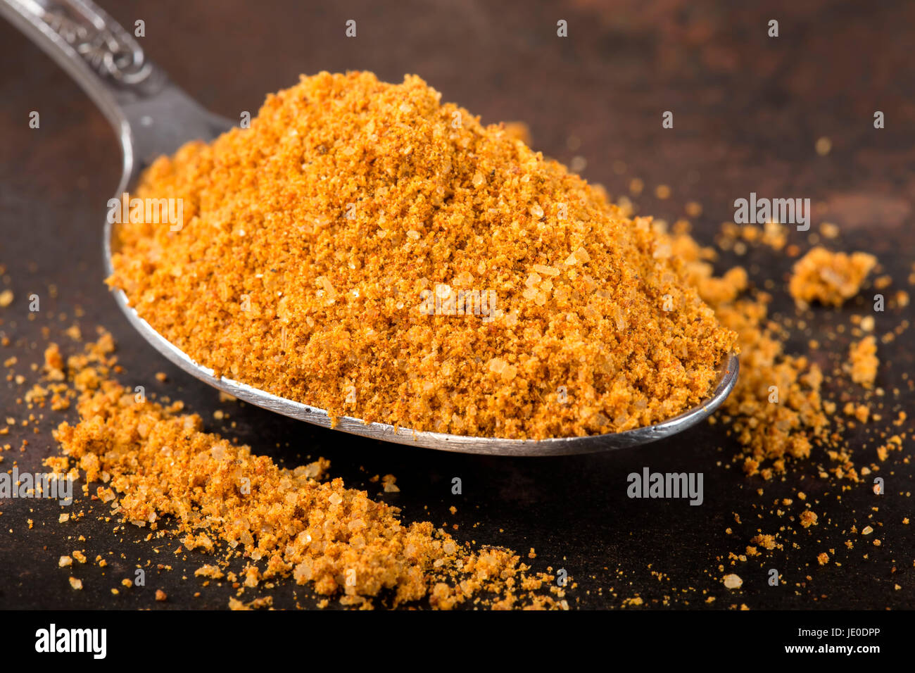 Spoon filled with spices for the preparation of roast on rusty ...