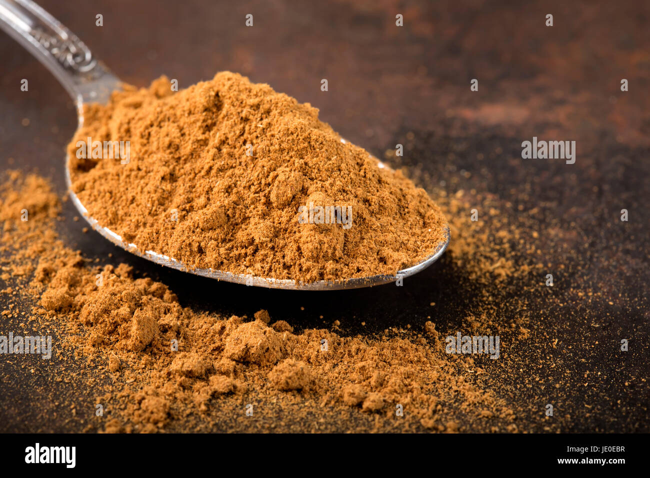 Spoon filled with cinnamon powder on rusty background Stock Photo - Alamy