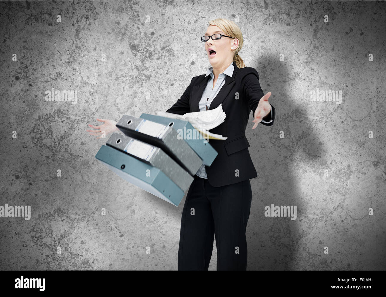Woman dropping her workload on grey wall background Stock Photo - Alamy