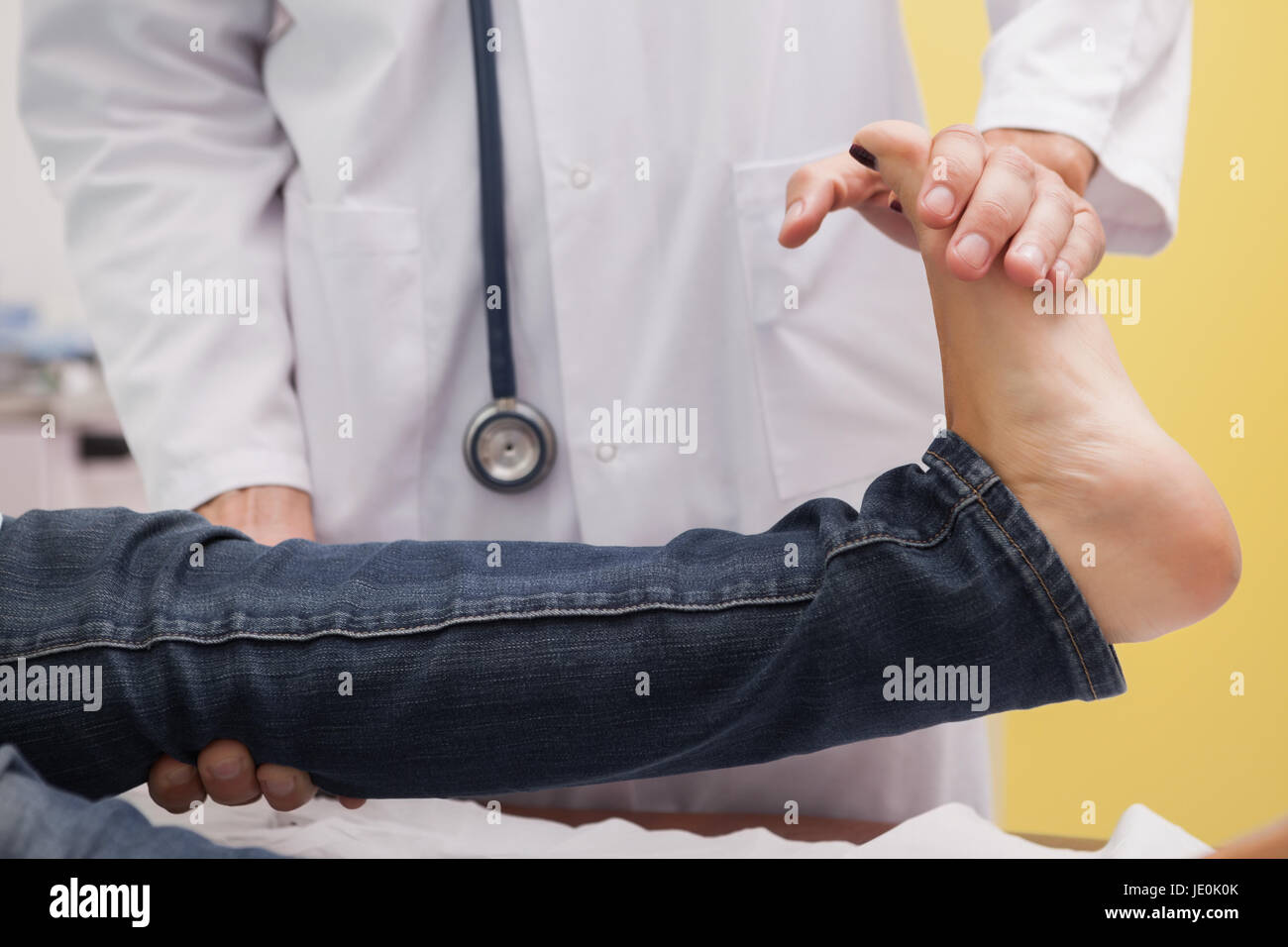 Doctor auscultating a patient ankle in examination room Stock Photo - Alamy