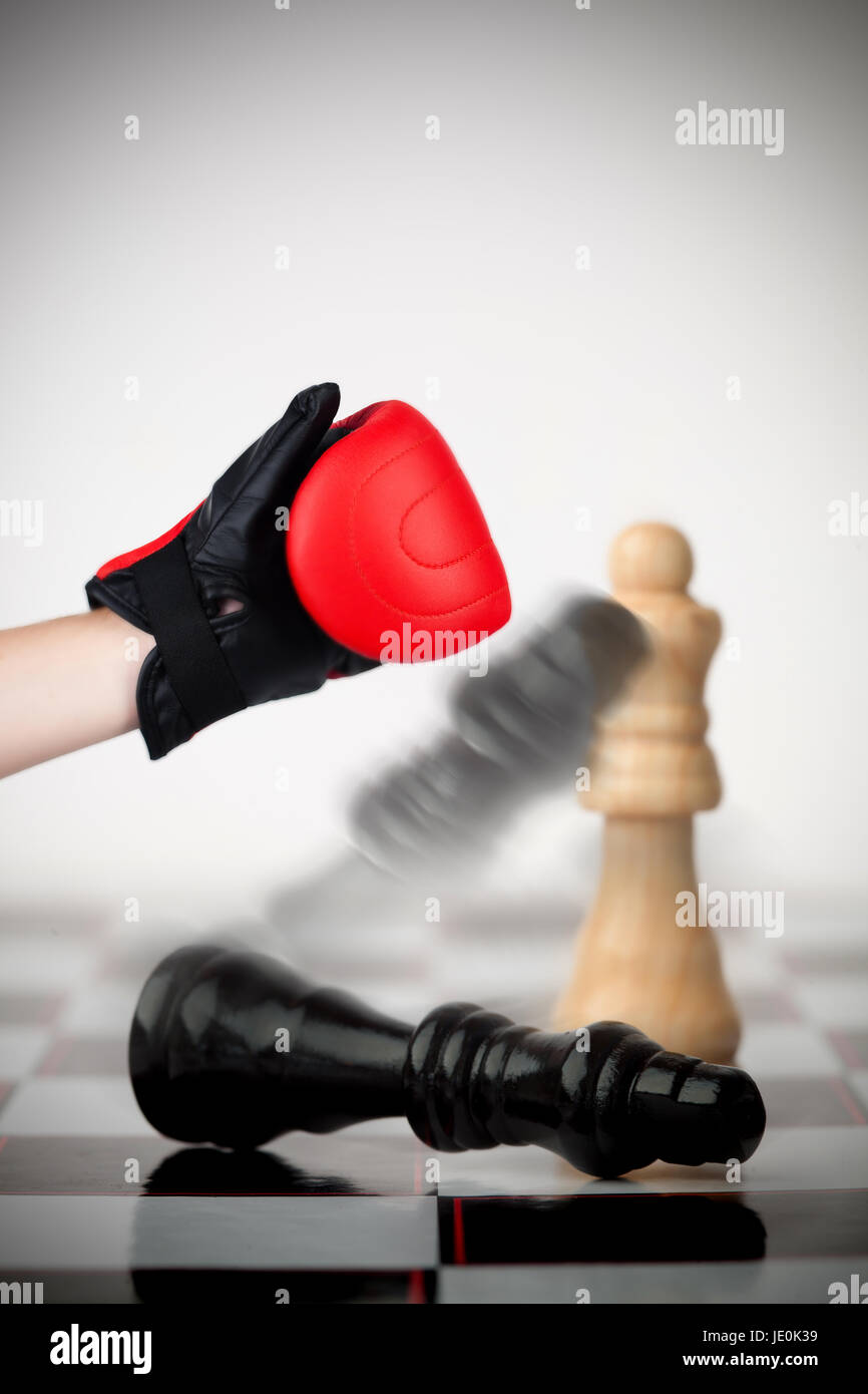 Hand of boxer knocking over black chess piece on chessboard Stock Photo ...