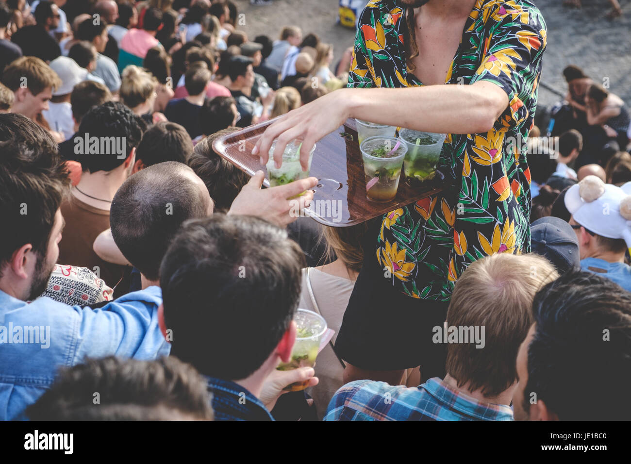 guy selling alcoholic drinks in crowded park Stock Photo - Alamy