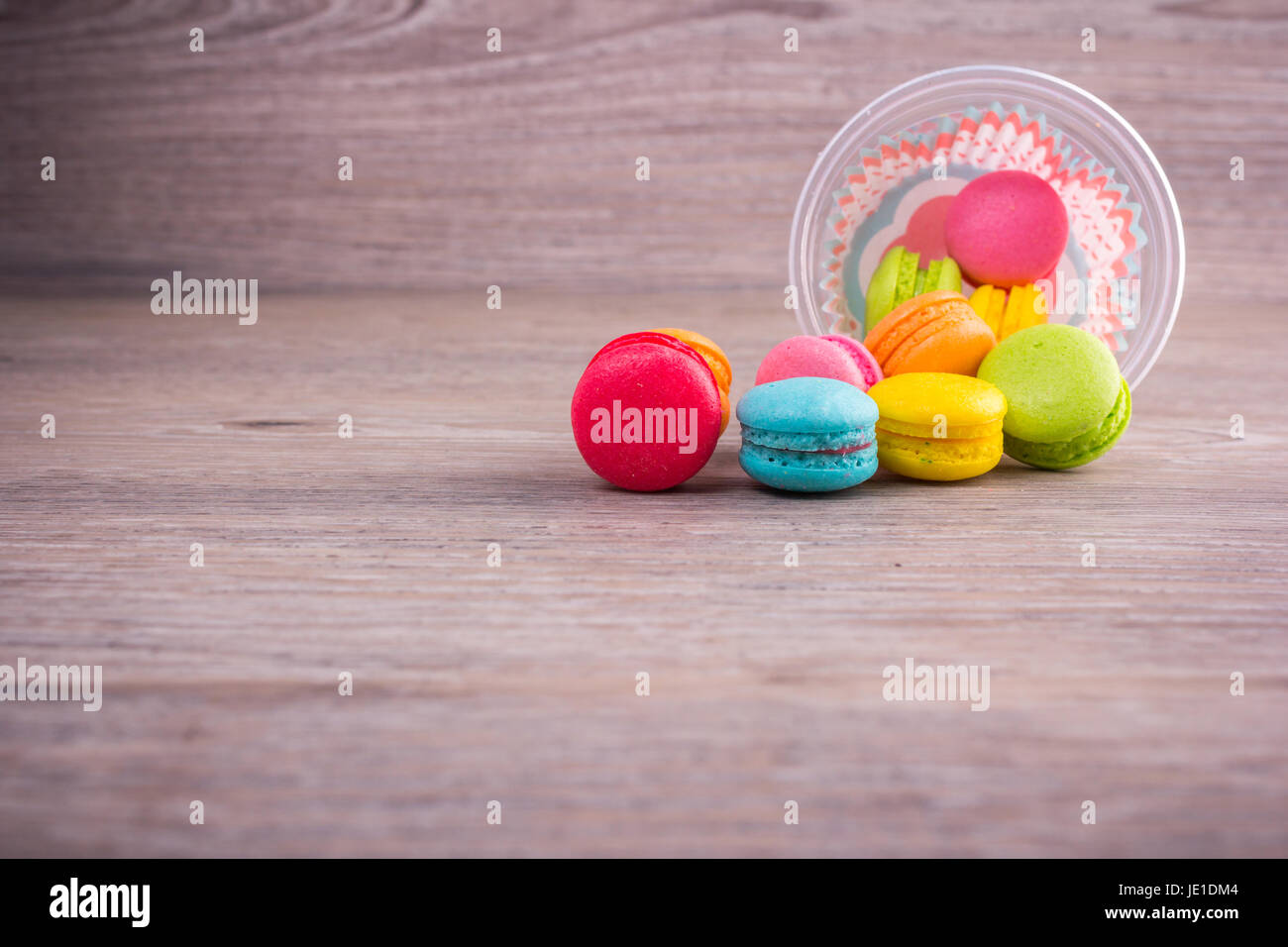 Sweet colorful macaroons on a wood background Stock Photo - Alamy