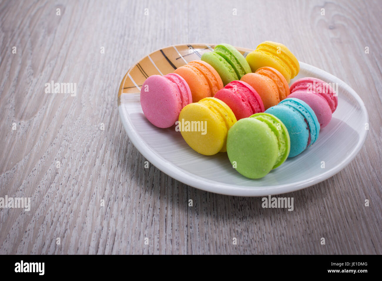 Sweet colorful macaroons on a wood background Stock Photo - Alamy