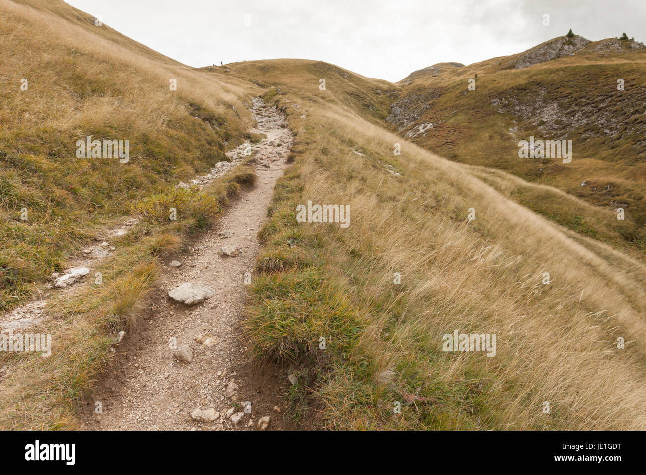 walking long a mountain path in Valle di Funes into the Italian ...