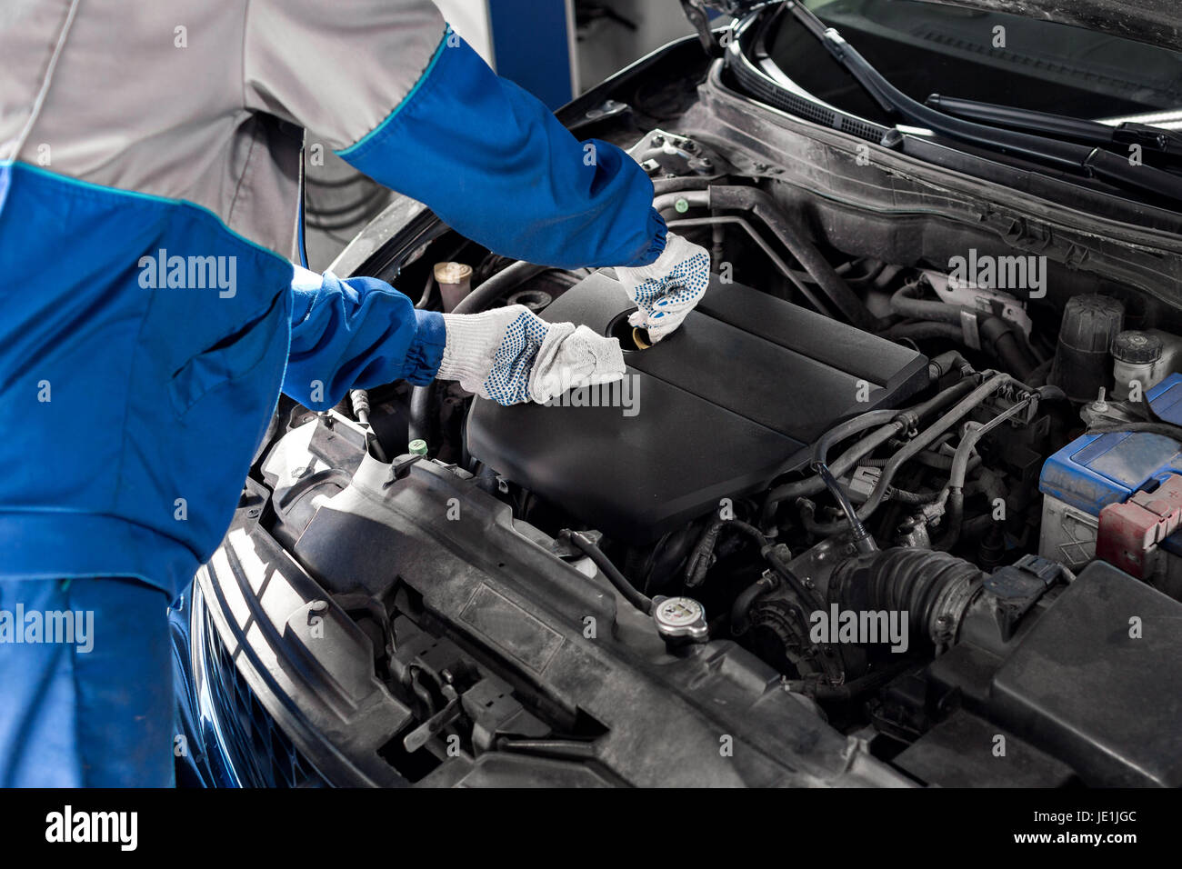 Mechanic checking oil level in a car workshop Stock Photo - Alamy