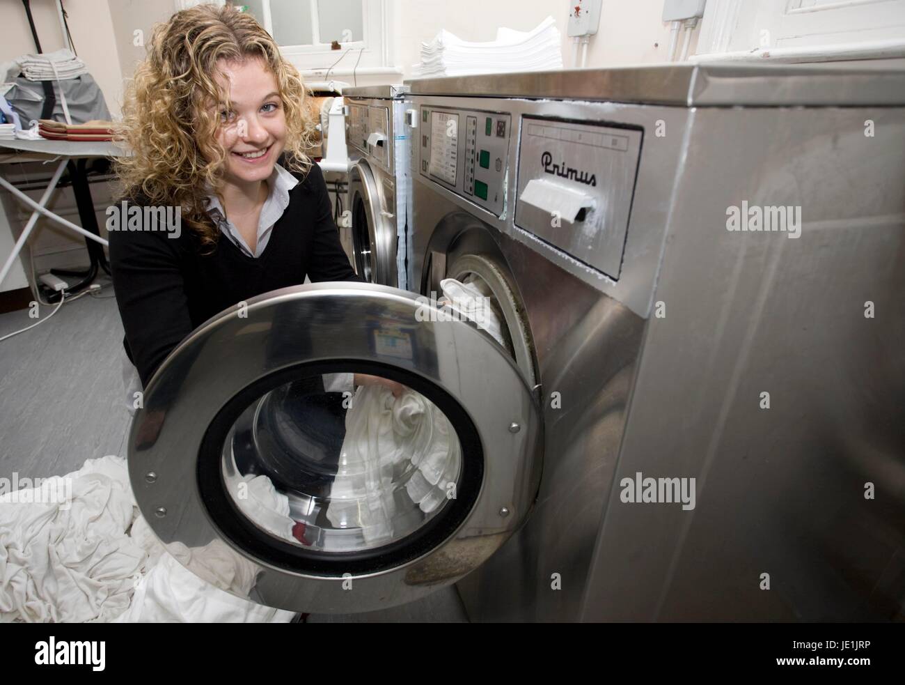A young smiley woman filling a washing machine with dirty laundry Stock ...