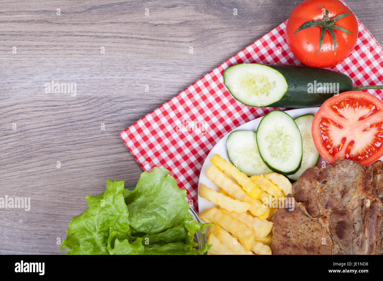 Very tasty meal on the table. Grilled pork with fries, fresh lettuce ...
