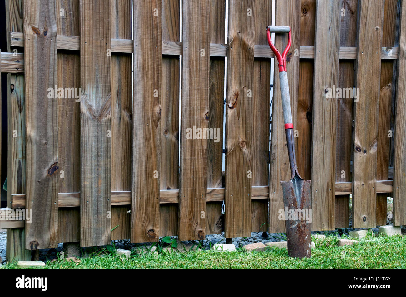 An old rusty shovel is leaning against a wooden fence Stock Photo - Alamy
