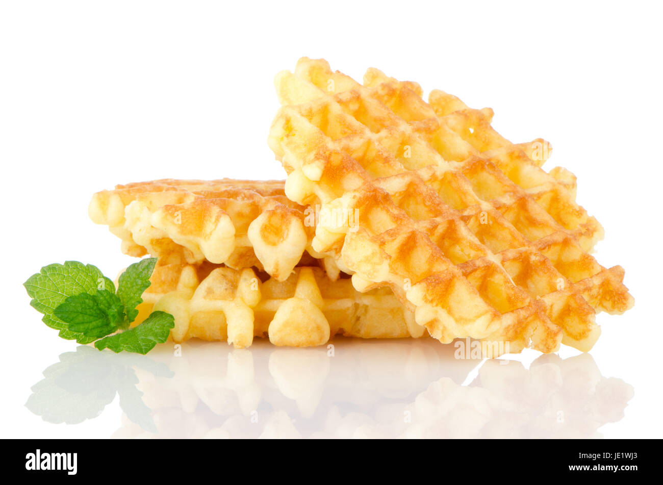 Pile of sweet waffles with green mint leaves isolated on white ...