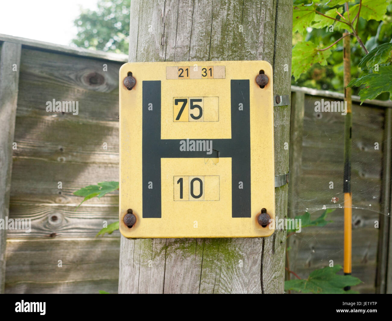 a yellow h sign outside on a wooden post in the street Stock Photo - Alamy