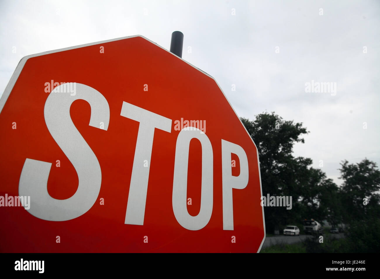 Color detail of a red "STOP" sign at a road junction Stock Photo - Alamy