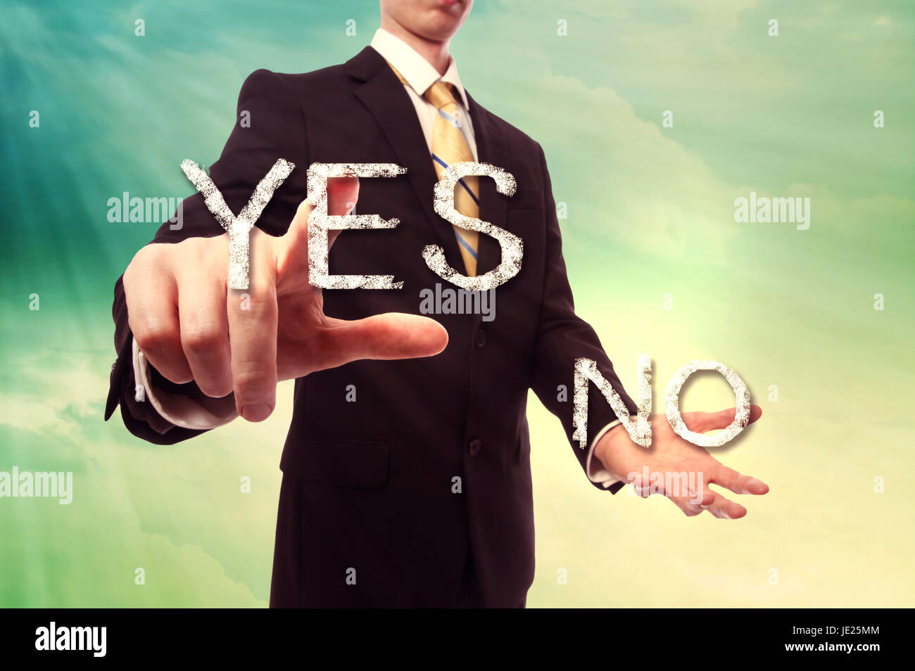 Businessman pointing YES over turquoise yellow colored sky background ...