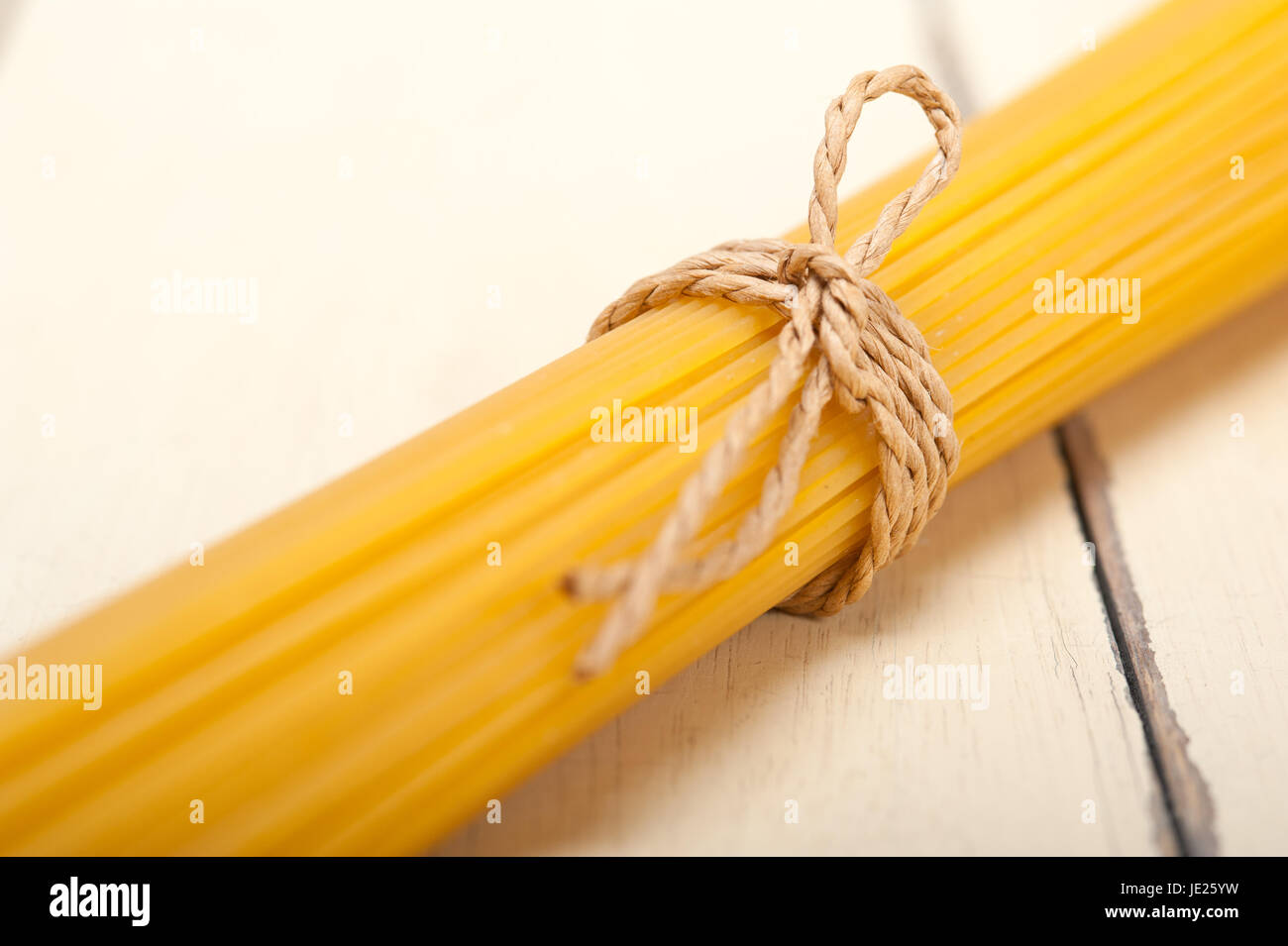 Italian pasta spaghetti tied with a rope on a rustic table Stock Photo ...