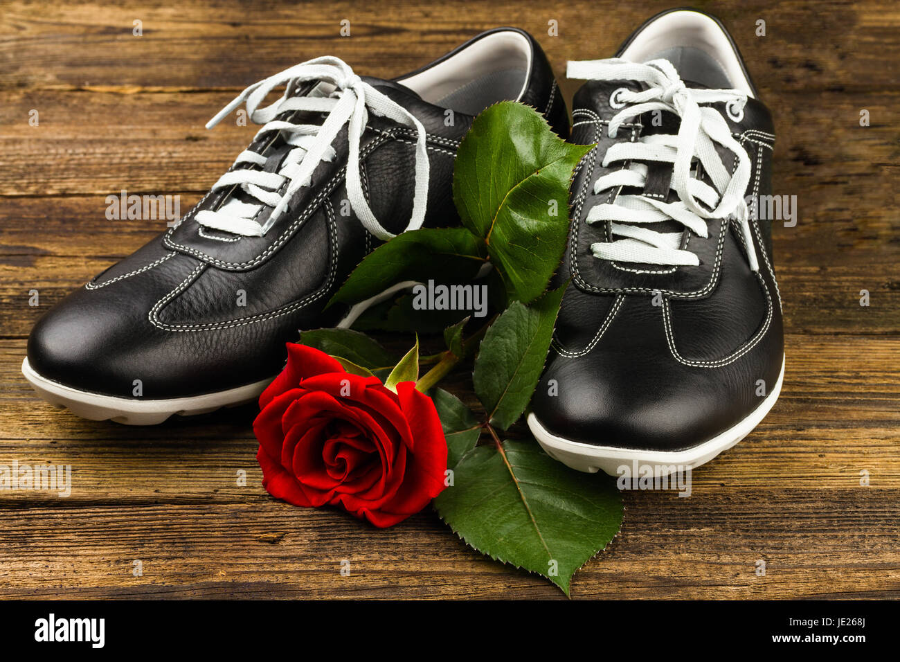 black man's shoes and rose on wooden background Stock Photo - Alamy