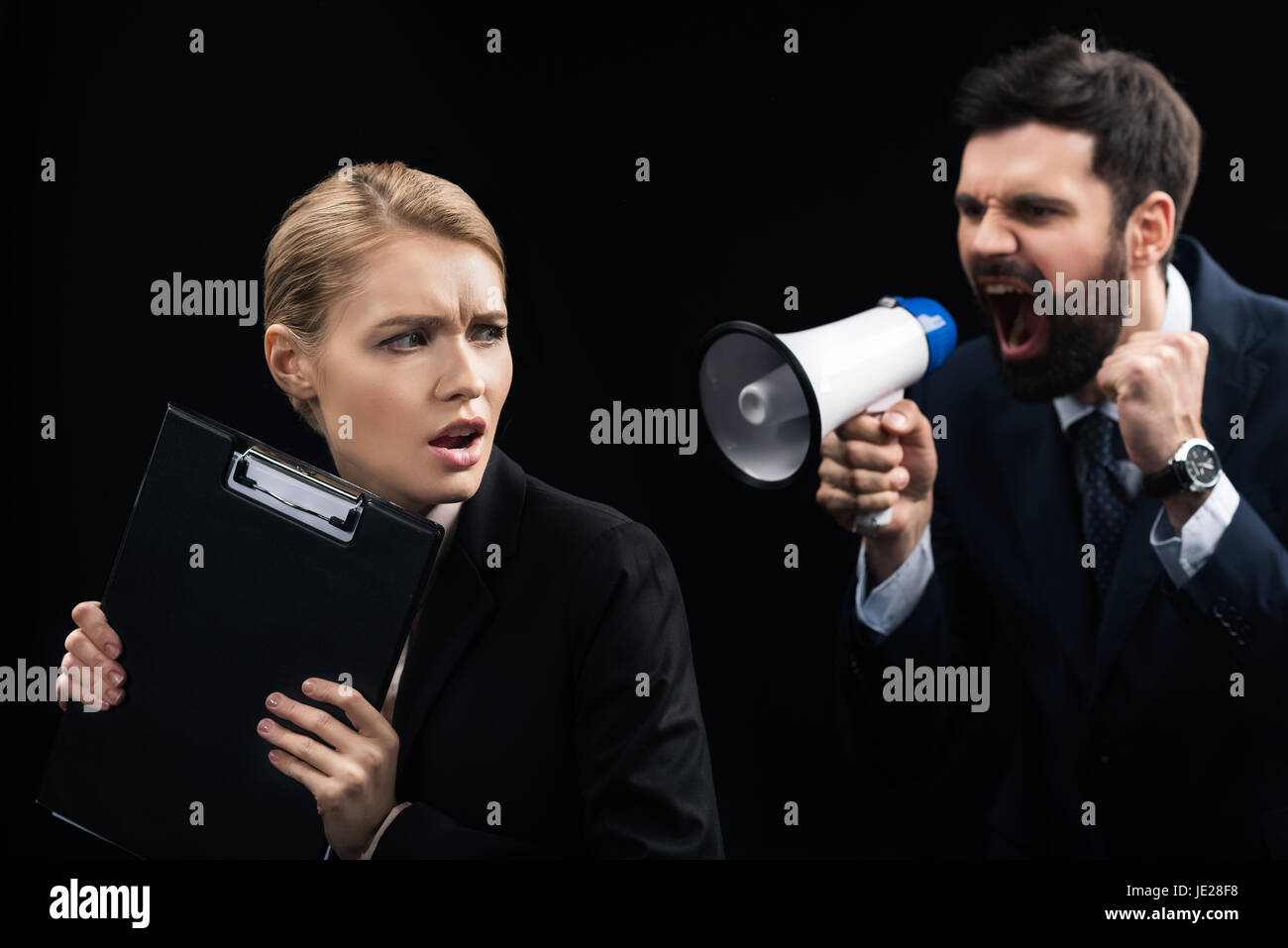 angry businessman with loudspeaker shouting on colleague isolated on ...