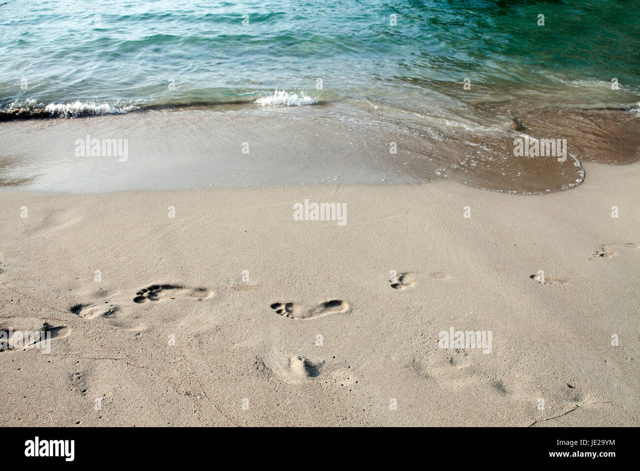 Footsteps in the sand on the beach Stock Photo - Alamy