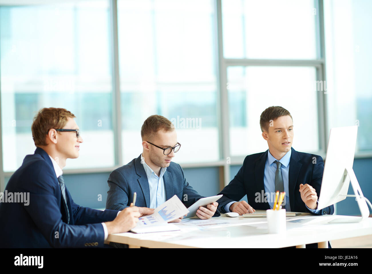 Three businessmen working together in office Stock Photo - Alamy