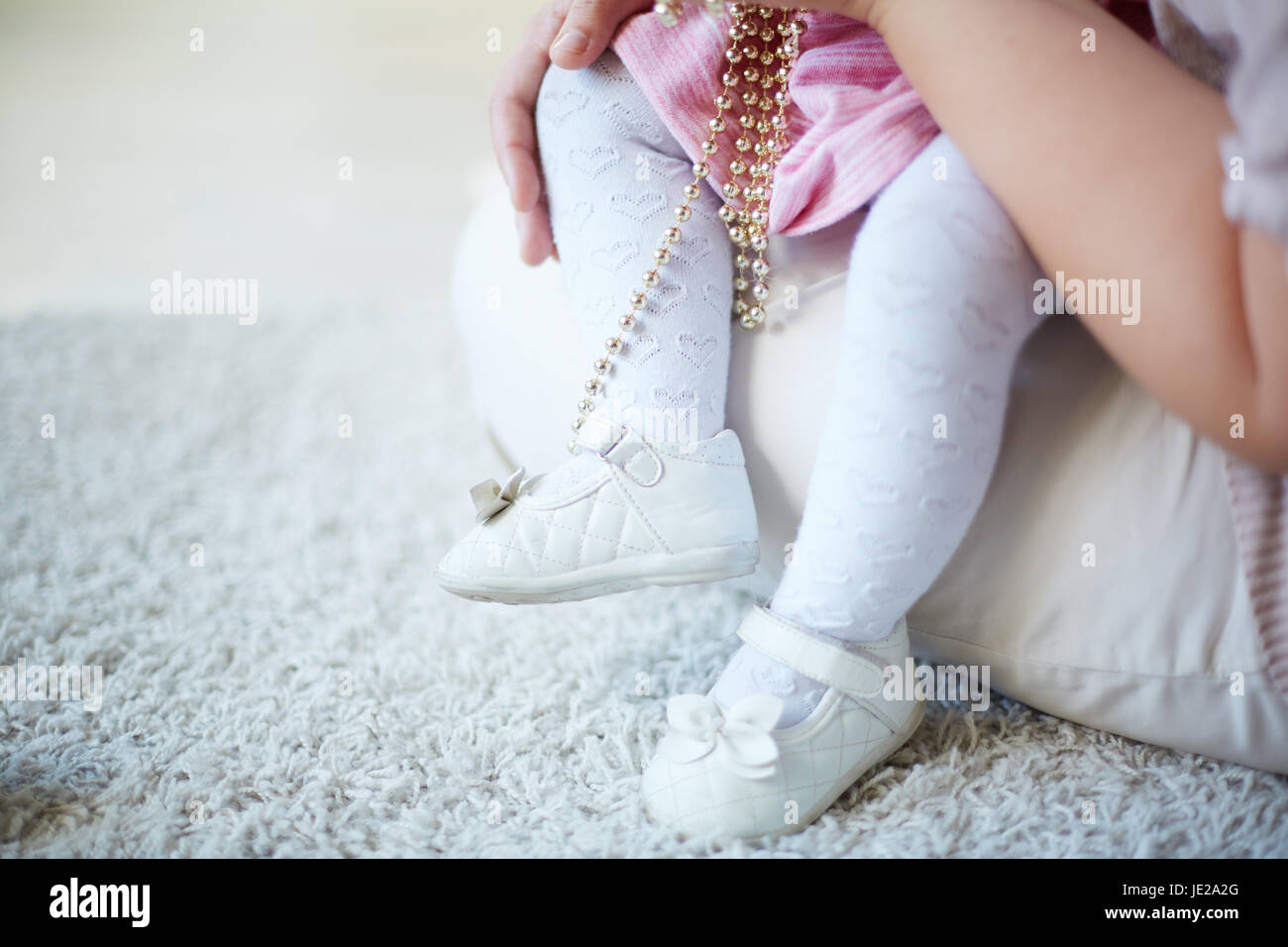 Legs of a toddler sitting on her mother’s laps Stock Photo - Alamy