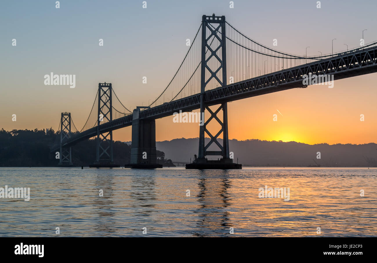 Sun Under the Bay Bridge at Dawn Stock Photo - Alamy