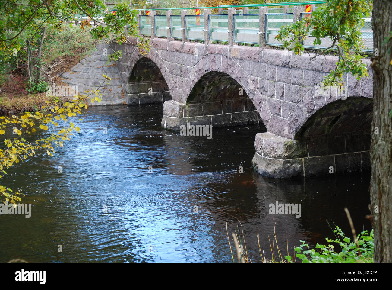 Old bridge with arches over a small river in a green landscape Stock ...