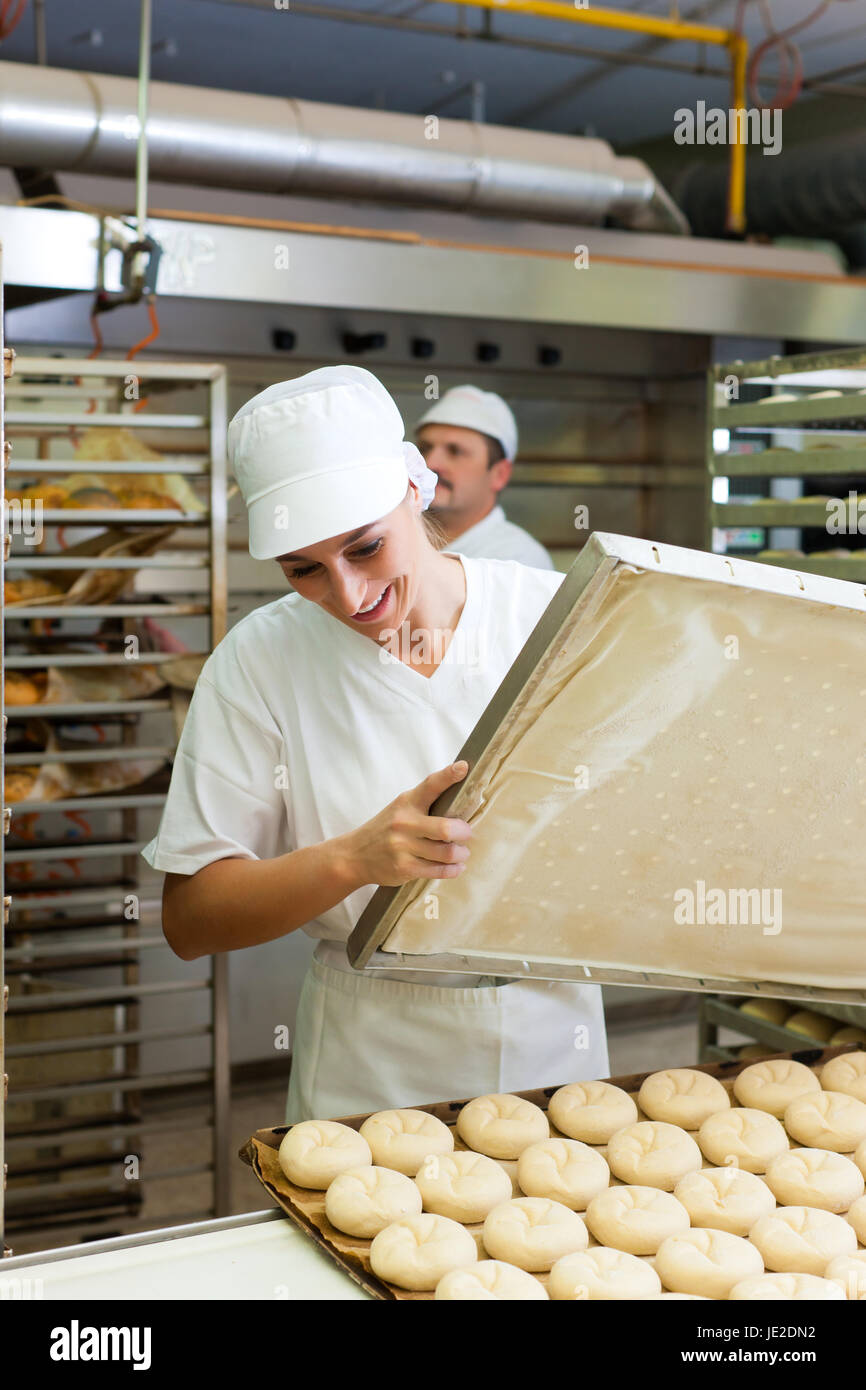 Female baker baking fresh bread rolls in the bakehouse Stock Photo - Alamy