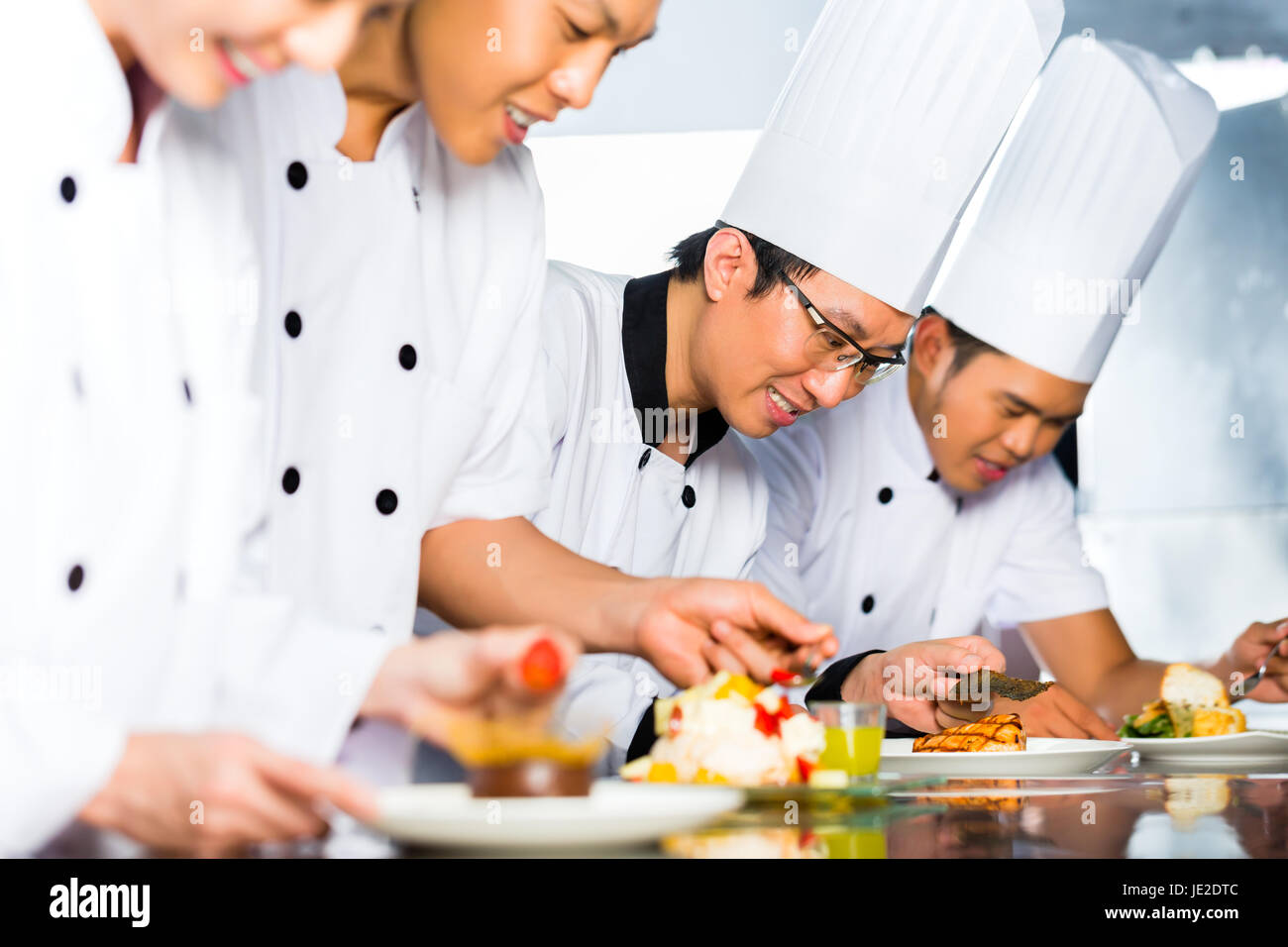 Asian Indonesian chef along with other cooks in restaurant or hotel ...