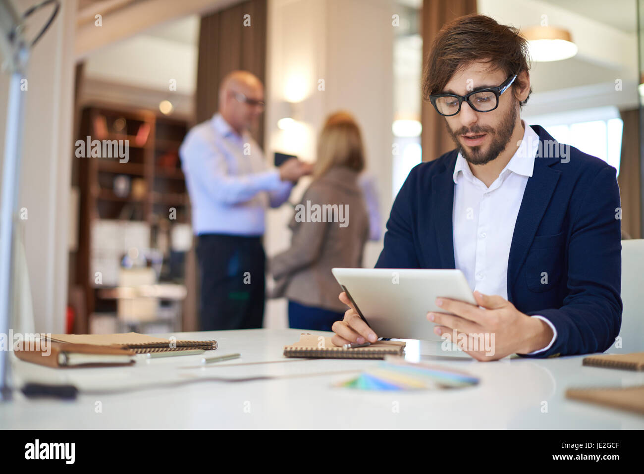 Handsome businessman in casual networking on background of his partners ...
