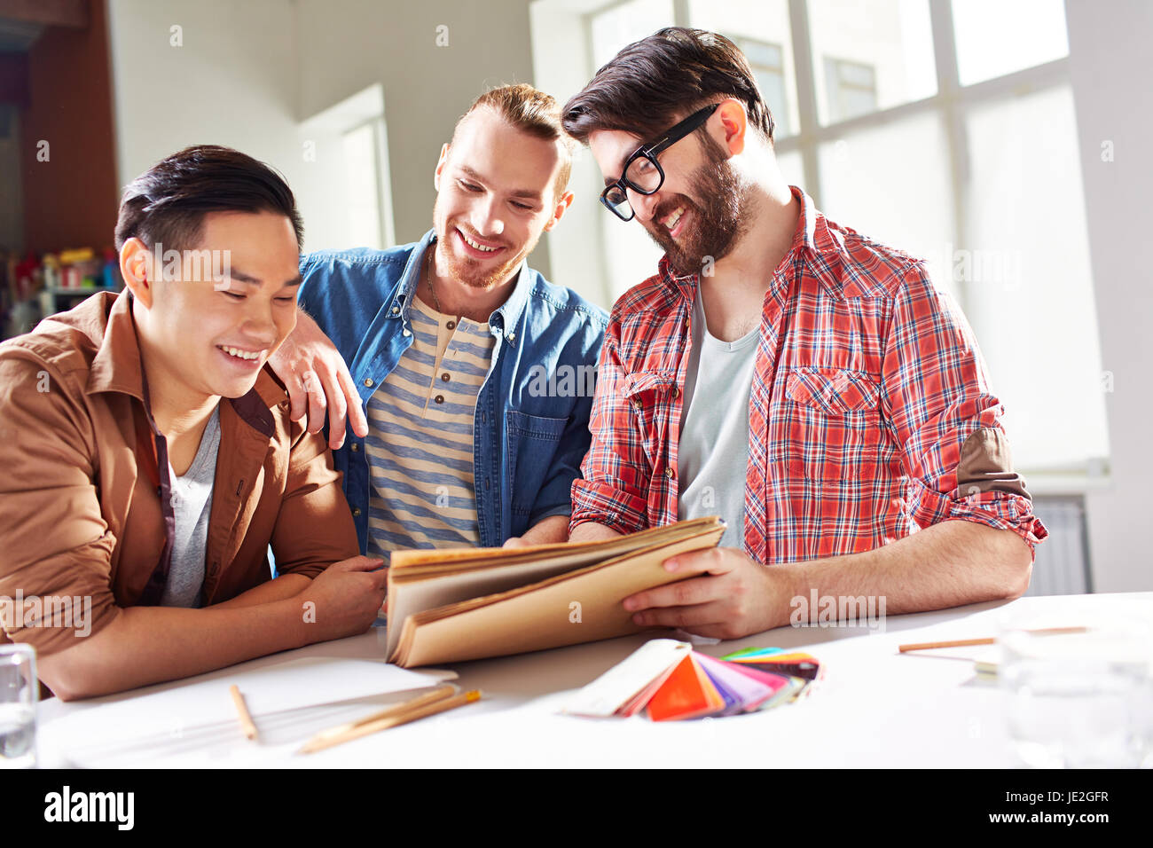 Team of three designers discussing a project Stock Photo - Alamy
