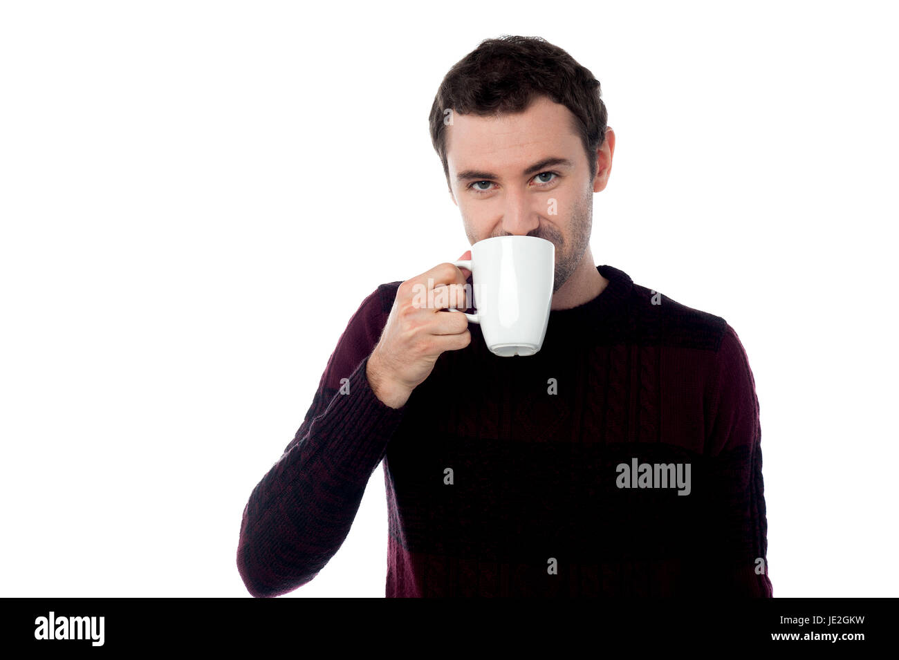 Handsome young man drinking coffee Stock Photo - Alamy