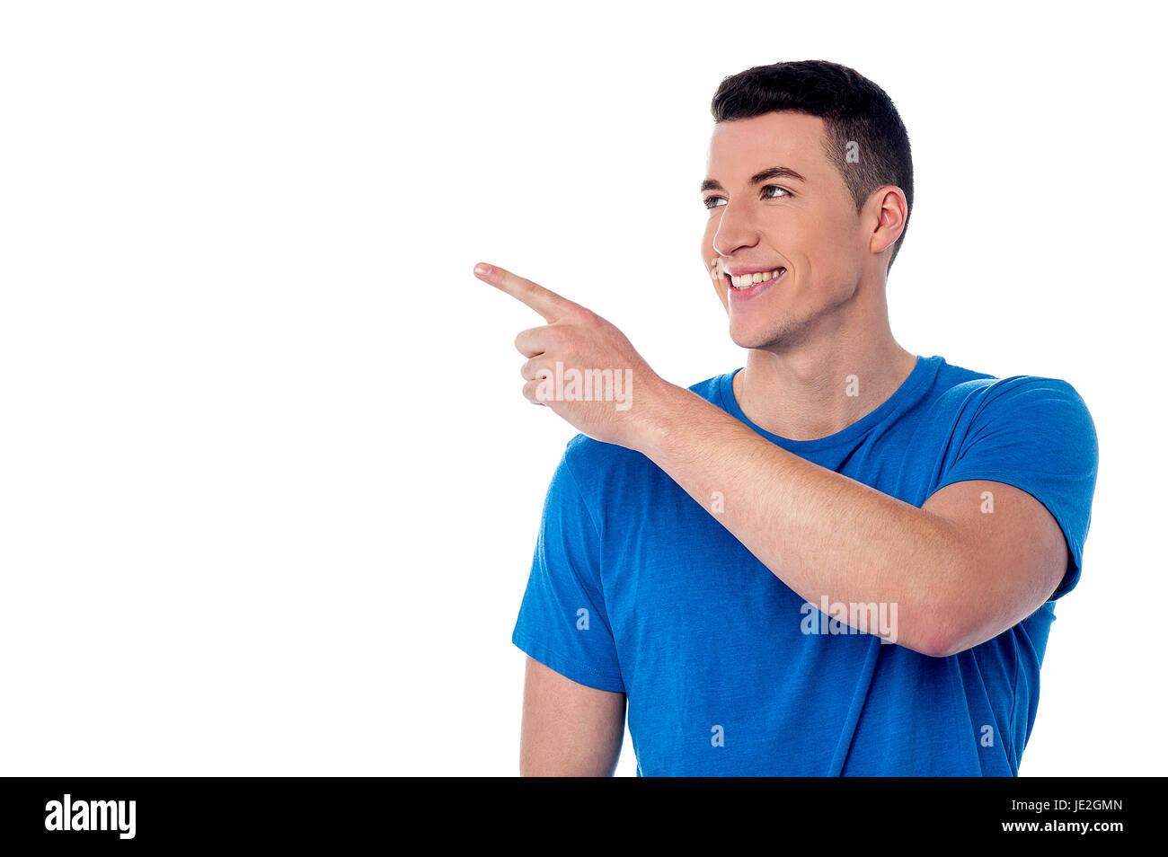 Smiling smart guy looking and pointing away Stock Photo - Alamy