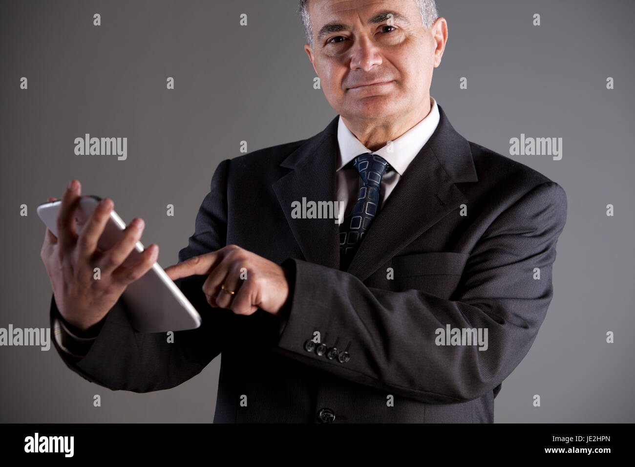 An old manager using successfully and with satisfaction a tablet Stock ...