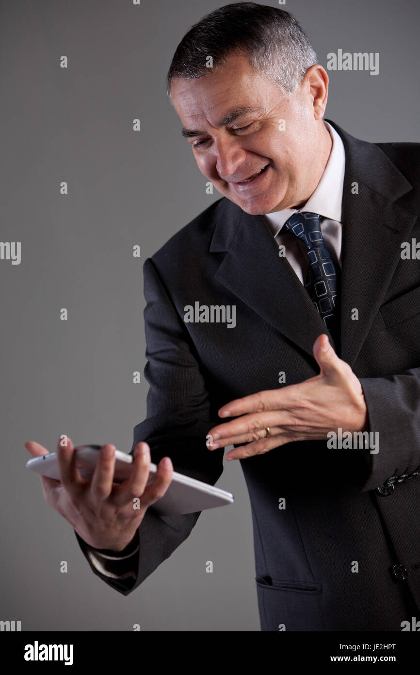 An old manager using successfully and with satisfaction a tablet Stock ...