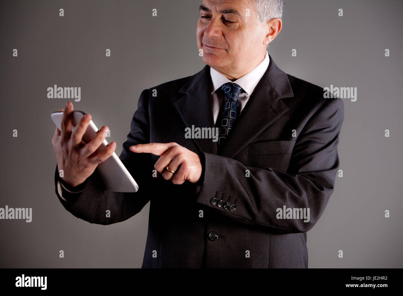 An old manager using successfully and with satisfaction a tablet Stock ...