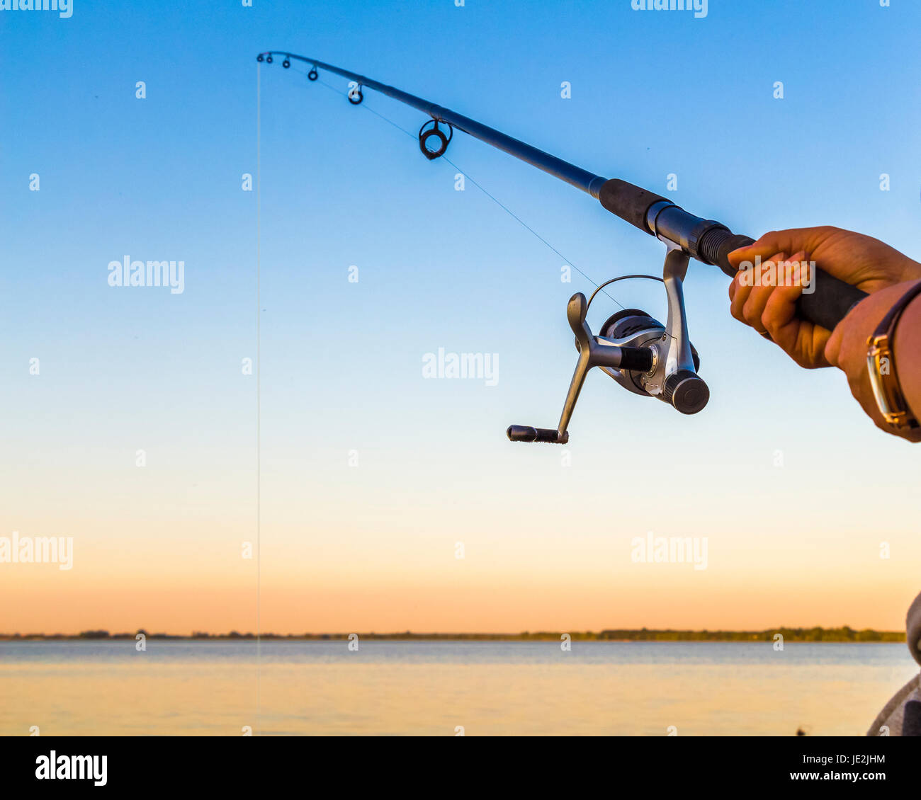 Fisherman fishing rod on the sunset close-up Stock Photo - Alamy