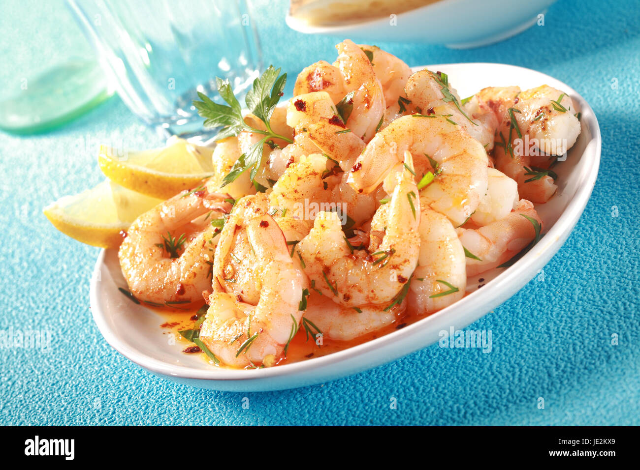 Dish of grilled shelled pink prawns seasoned with virgin olive oil and ...