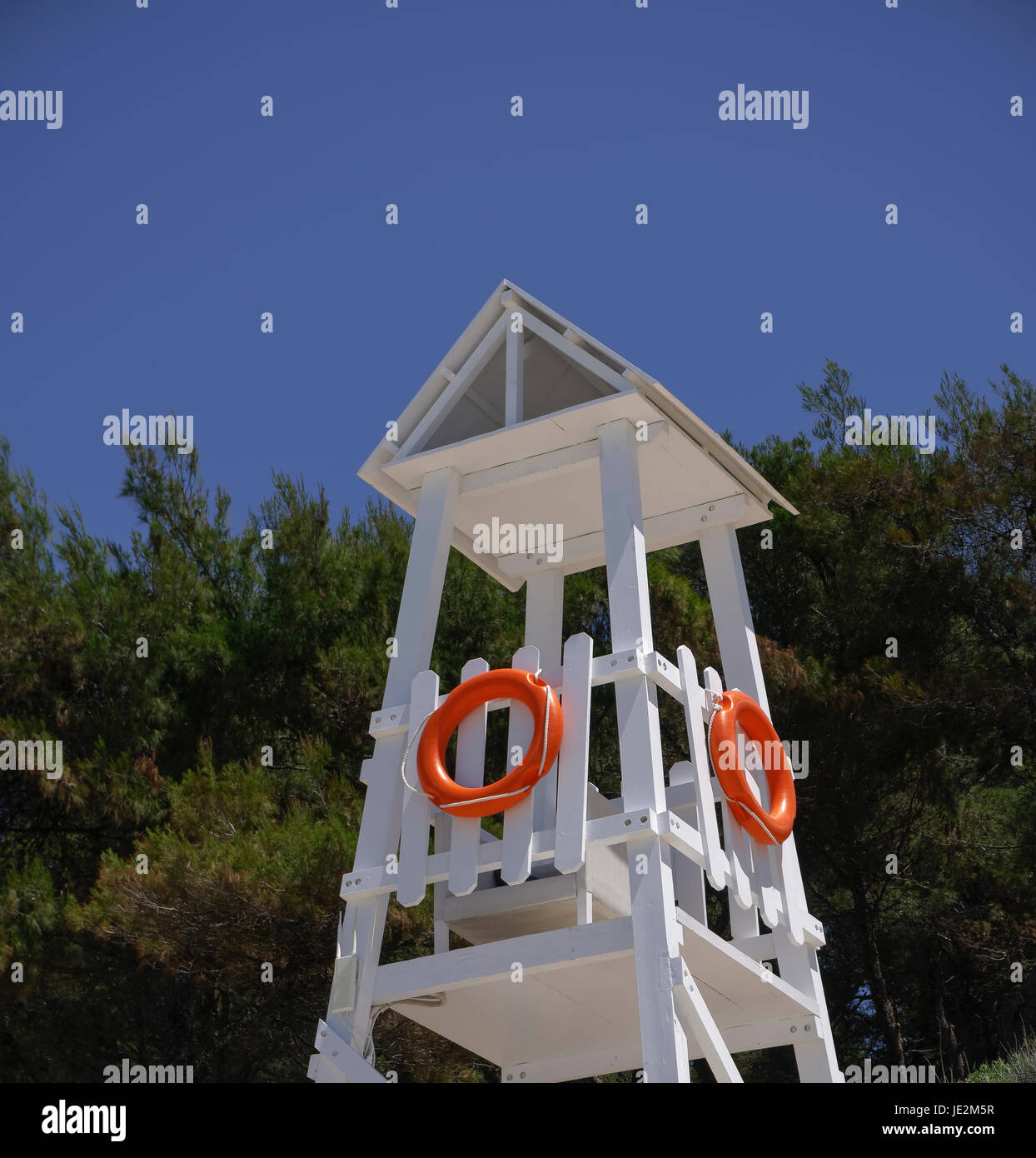 Lifeguard tower with orange lifebuoy by the beach. White lifeguard ...